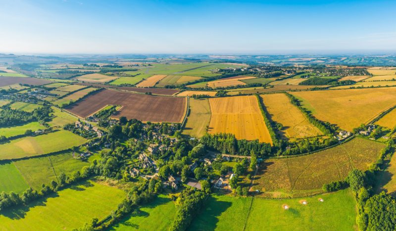 Aerial photograph over green pasture crop fields farms country villages ...